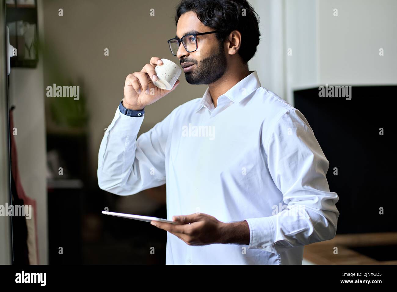 Smiling rich successful indian business man drinking coffee in morning ...