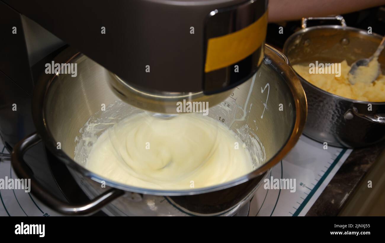 Male hands add the ingredient cream for baking in the bowl of a food ...