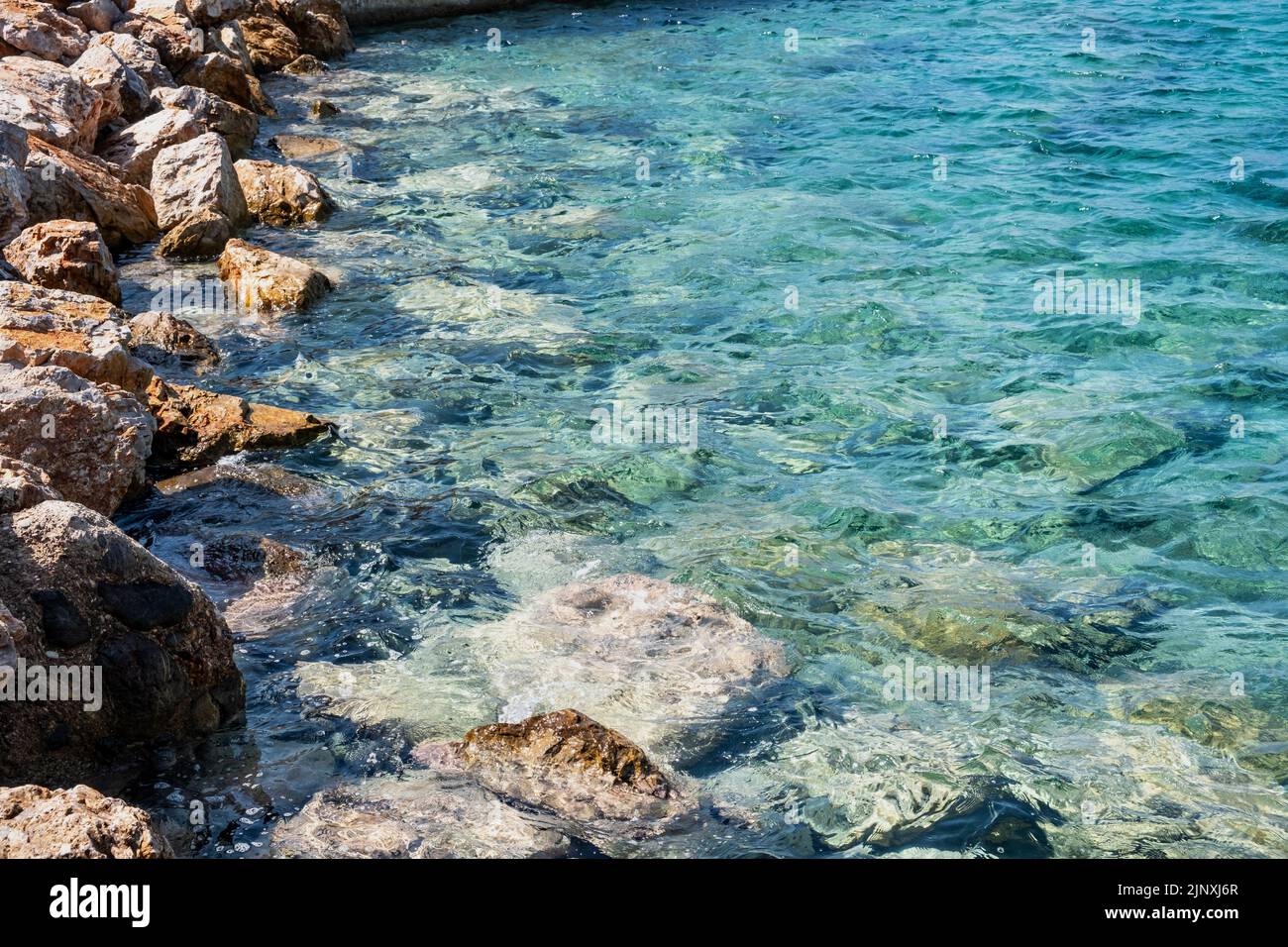 Sea waves with white foam splash on rough rocks at empty rocky beach ...