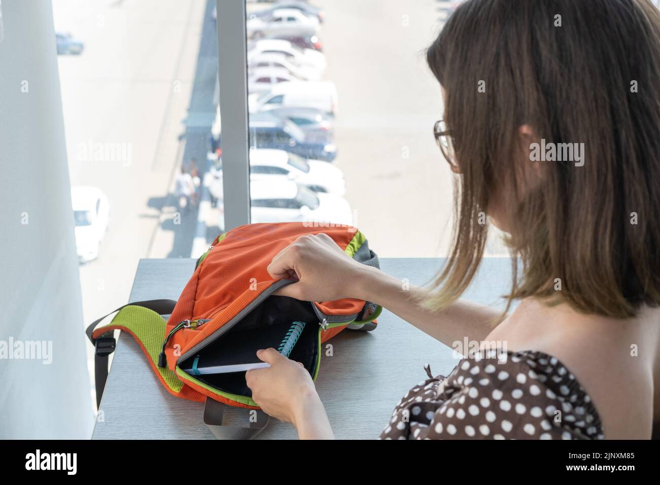 The student takes out stationery, books from a backpack. A teen girl ...
