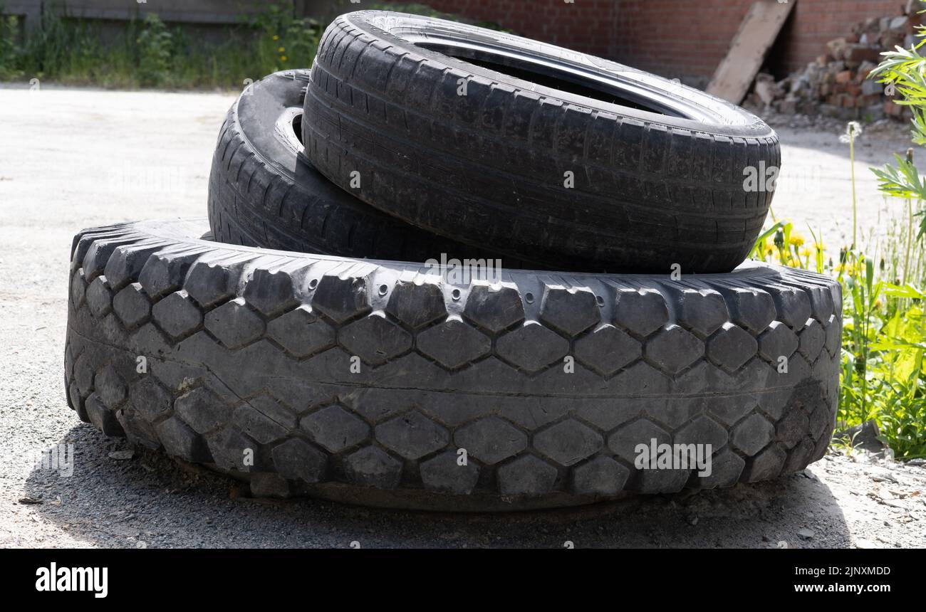 Old used tires of cars and trucks are piled up and stored for recycling ...