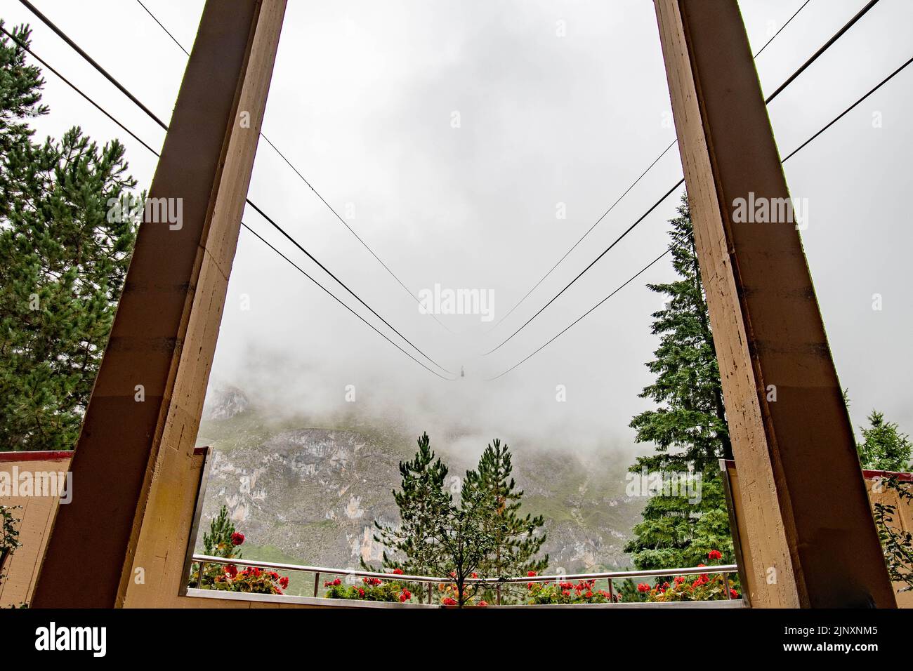 A view to funicular cabins lifting up to the mountains covered by thick ...