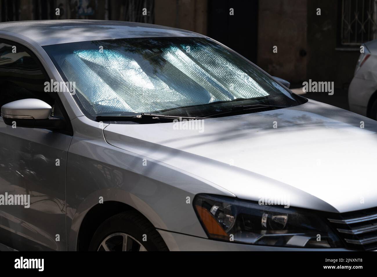 Protective reflective surface under windshield of car on hot day ...