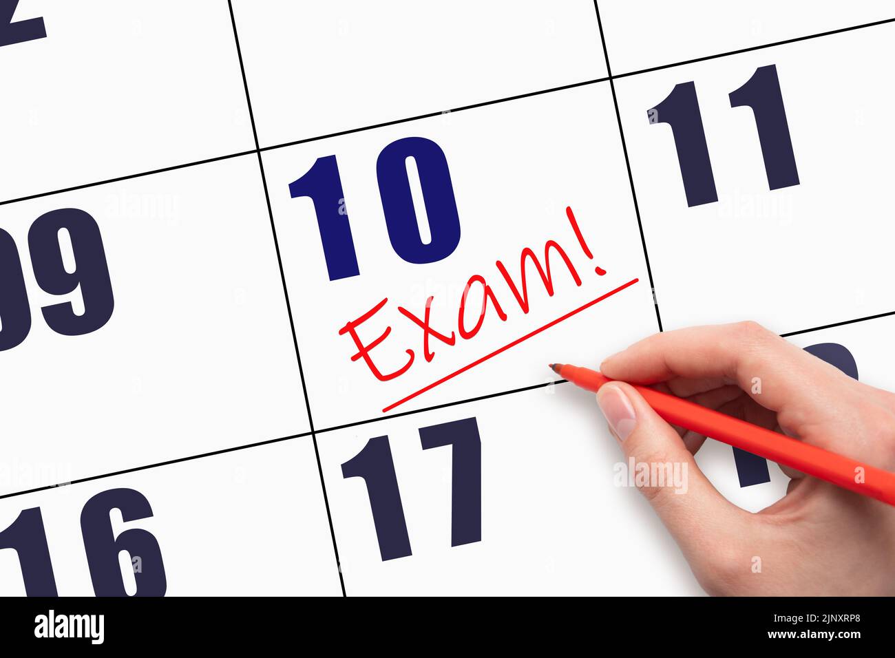 10th day of the month. Hand writing text EXAM and drawing a line on ...