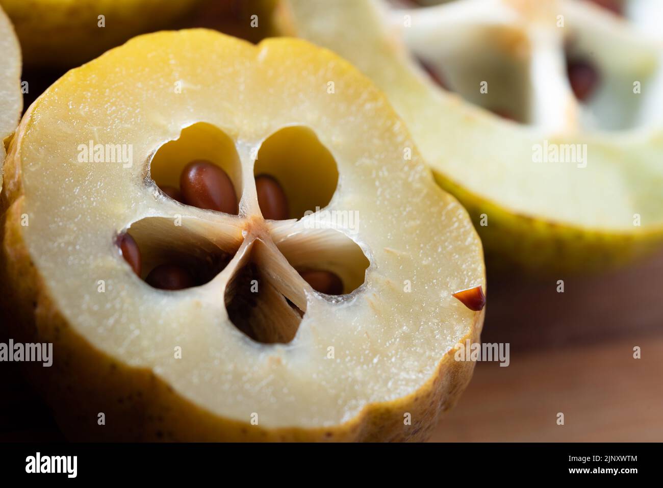 Close-up of Japanese quince. Cross-sectioned fruit with seeds in a seed ...