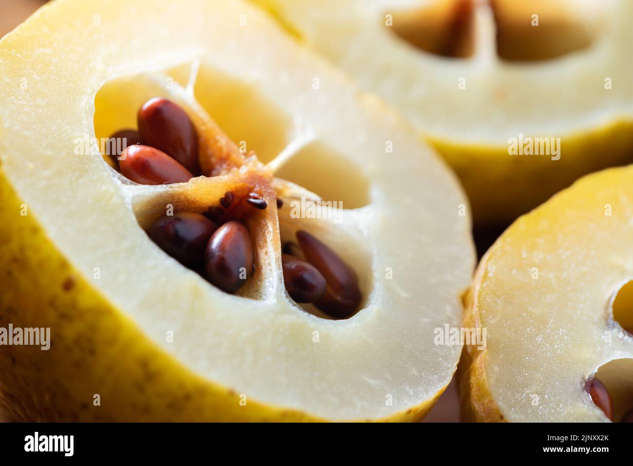 Close-up of Japanese quince. Cross-sectioned fruit with seeds in a seed ...