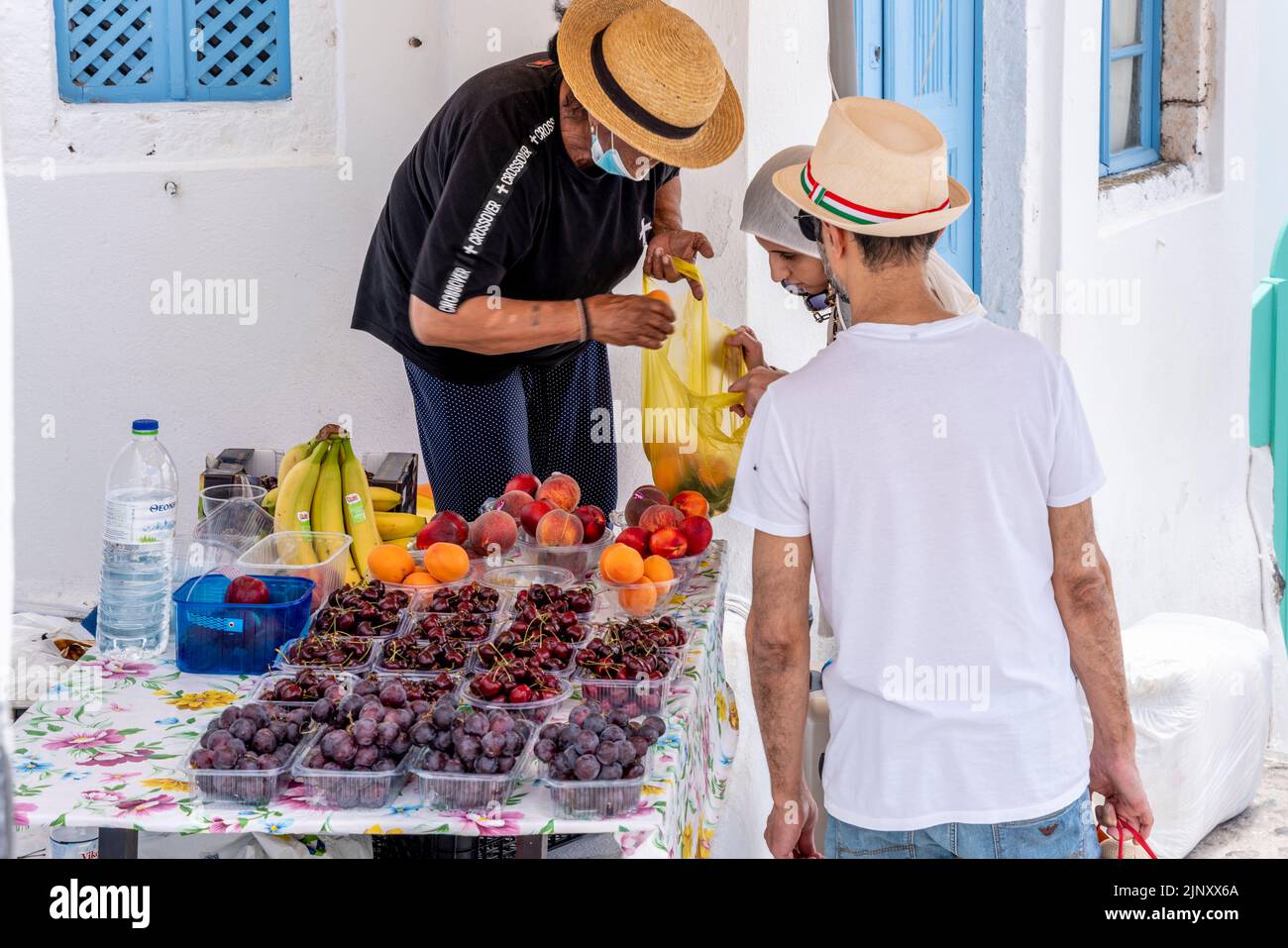 Tourists/Visitors Buying Fresh Fruit From A Stall In The Town Of Oia ...