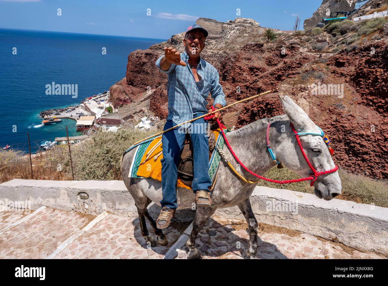 A Local Man Travels Up The Steep Path From The Port Of Oia To The Town ...