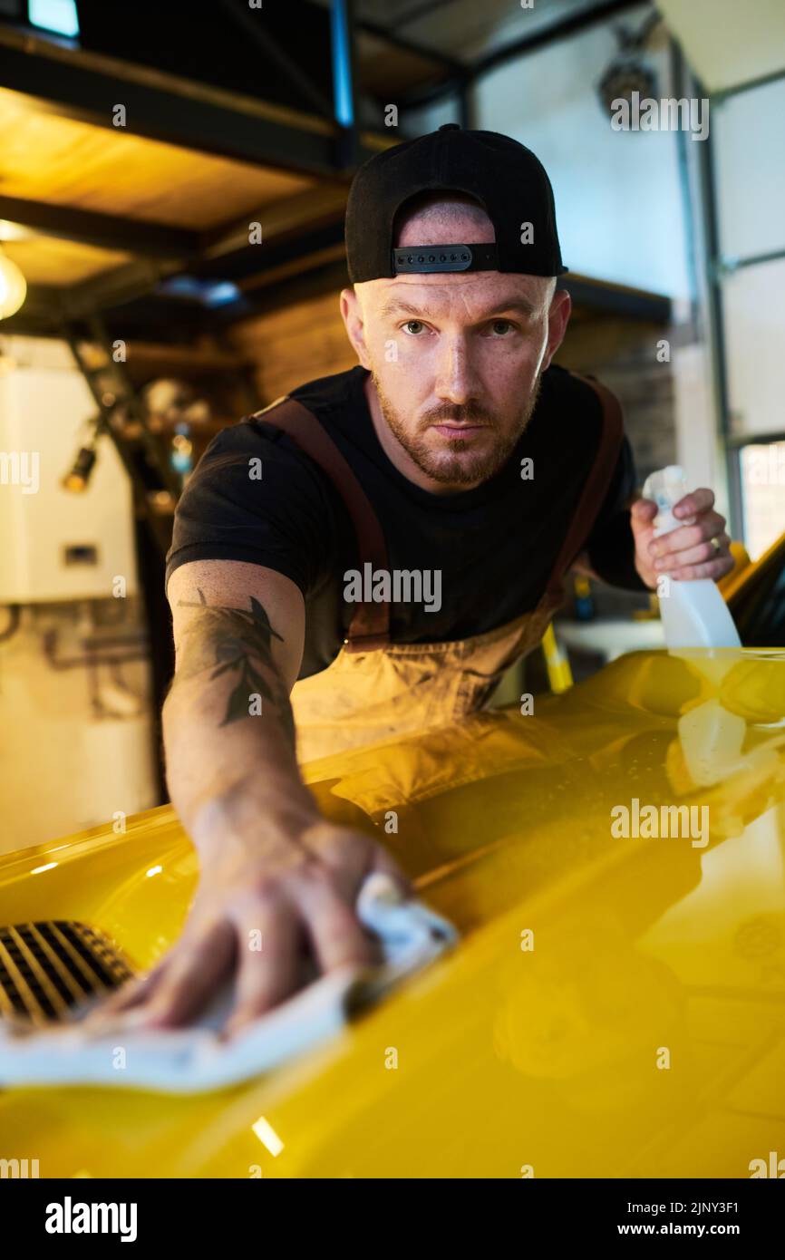 Young male worker of maintenance service with bottle of detergent ...