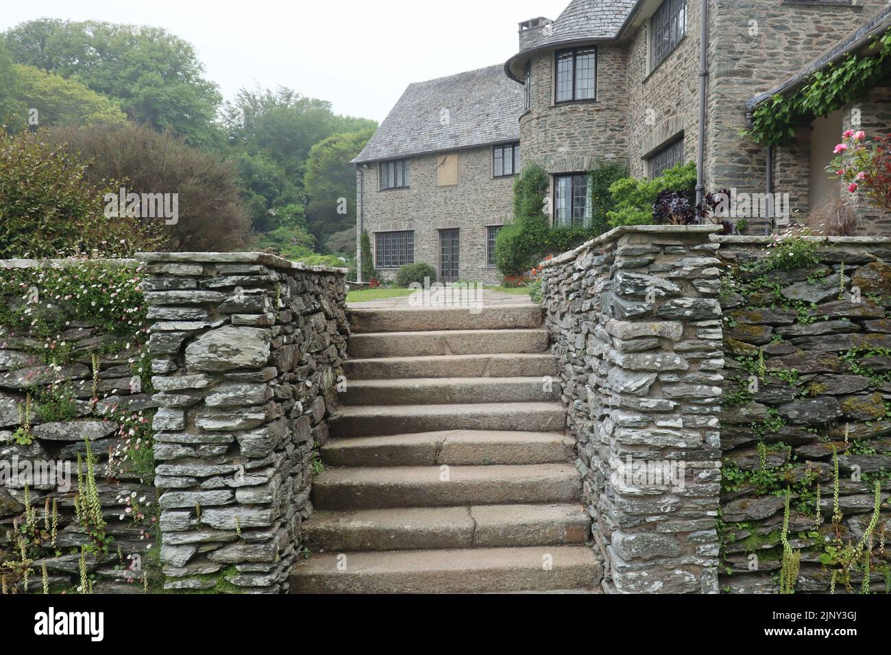 Old steps lead up towards the house and patio from the lawn in the ...