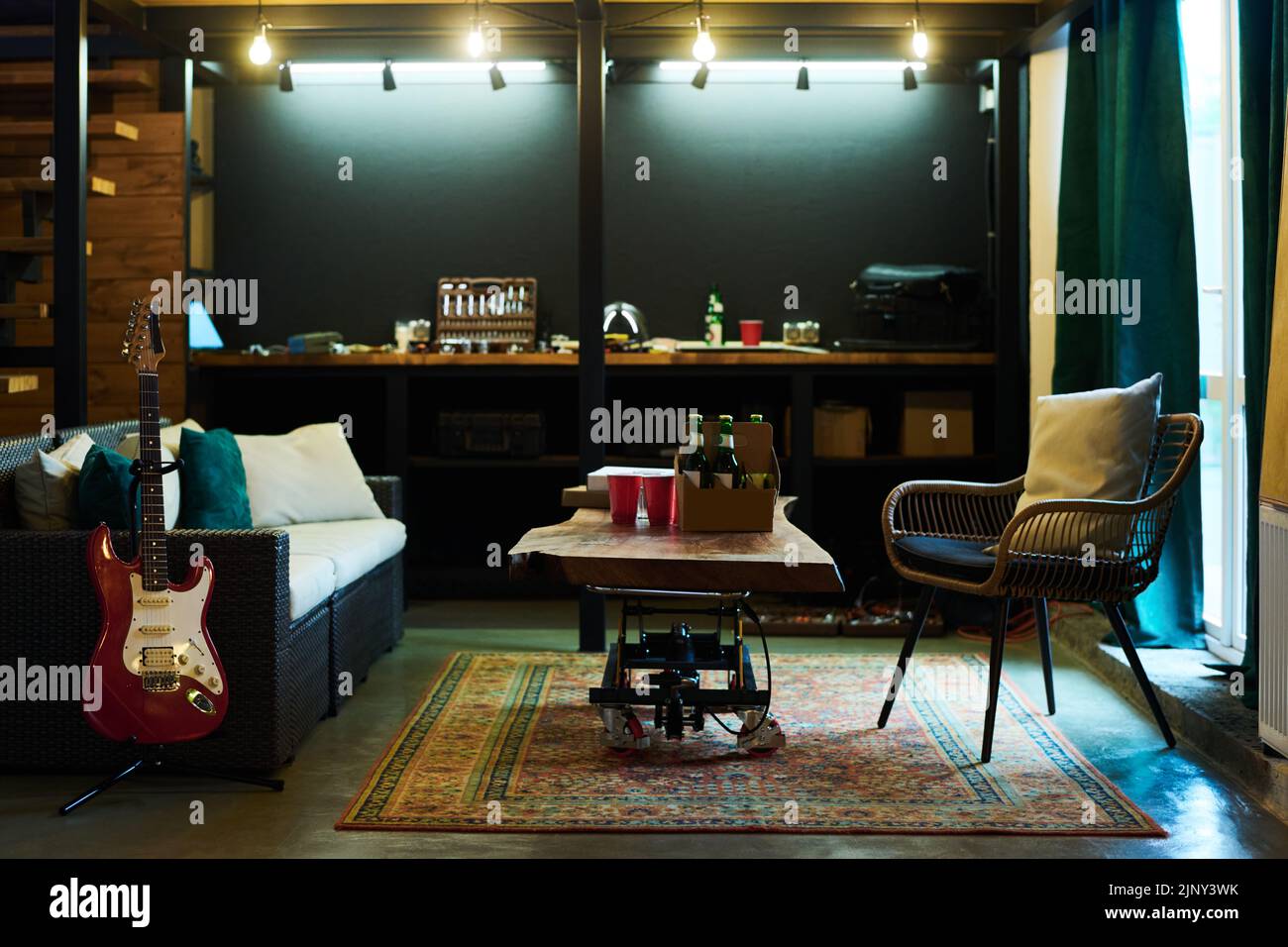 Table with bottles of beer, cups and boxes standing between armchair ...