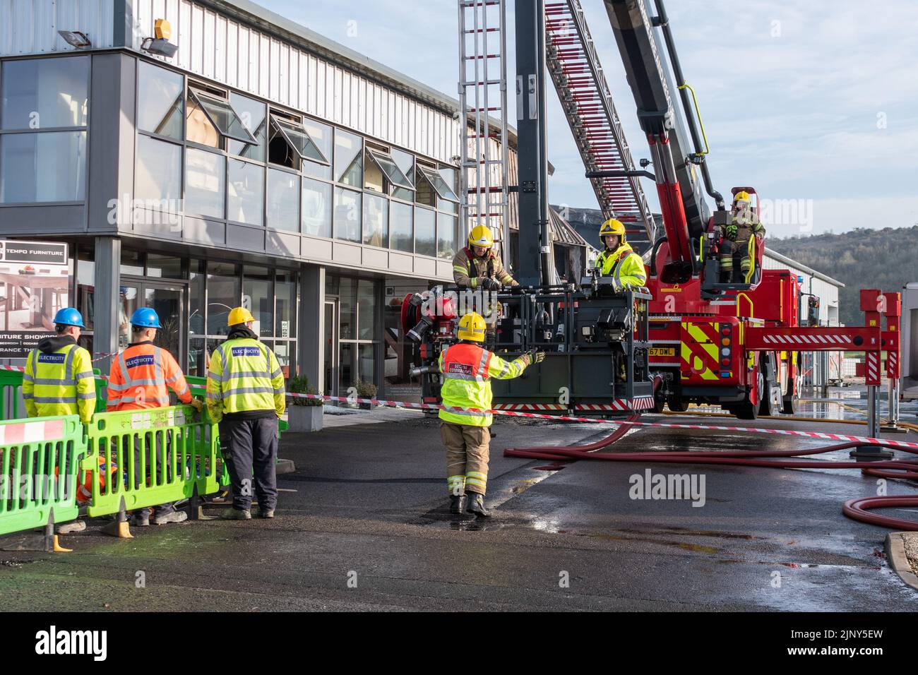 2 fire crew in a high lift platform consult with a commander, with a ...