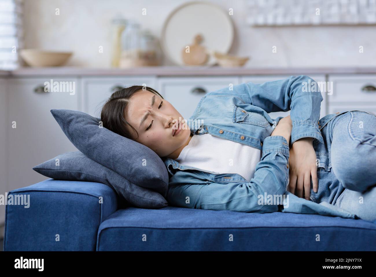 Young beautiful woman sick alone at home lying on bed, Asian girl ...