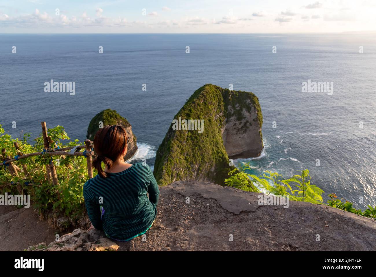 Rear view of woman with ocean and cliff view at Manta point Kelingking ...