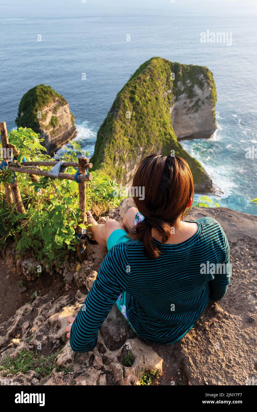 Rear view of woman with ocean and cliff view at Manta point Kelingking ...