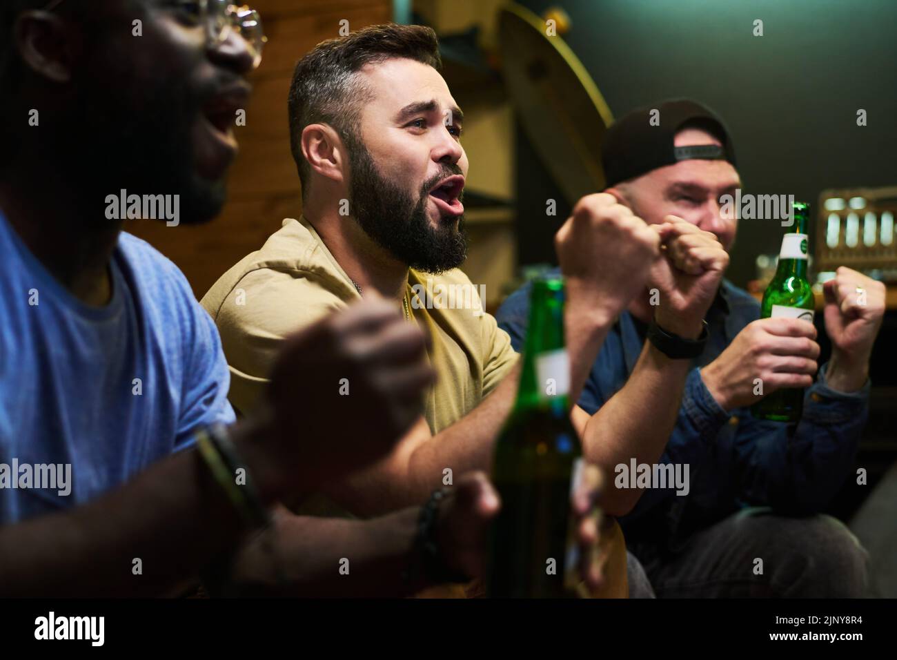 Group of football fans expressing joy and shouting excitedly while ...
