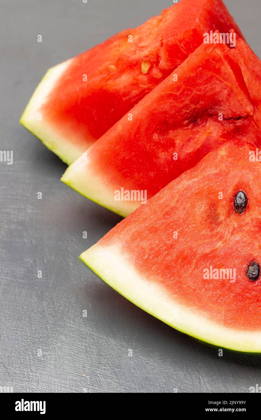 Three pieces of watermelon, part of the frame. Close up. Top view. Grey ...