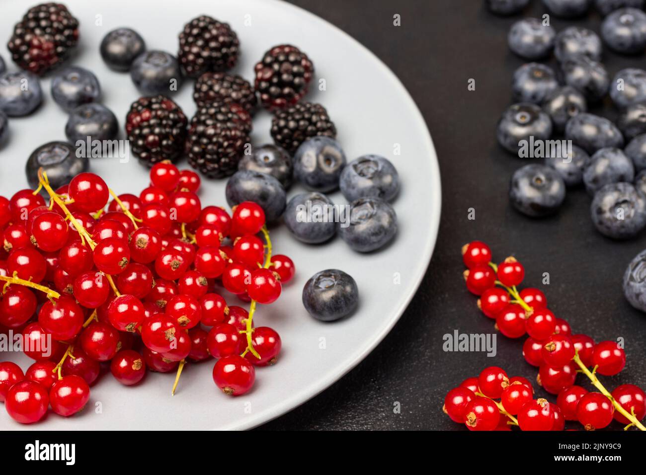 Berries of ripe red currants, blackberries and blueberries on gray ...