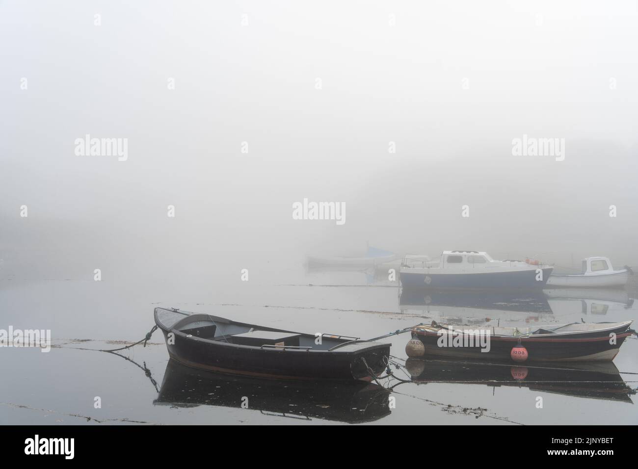 Boats in heavy sea fret at the harbour, at high tide in Seaton Sluice ...