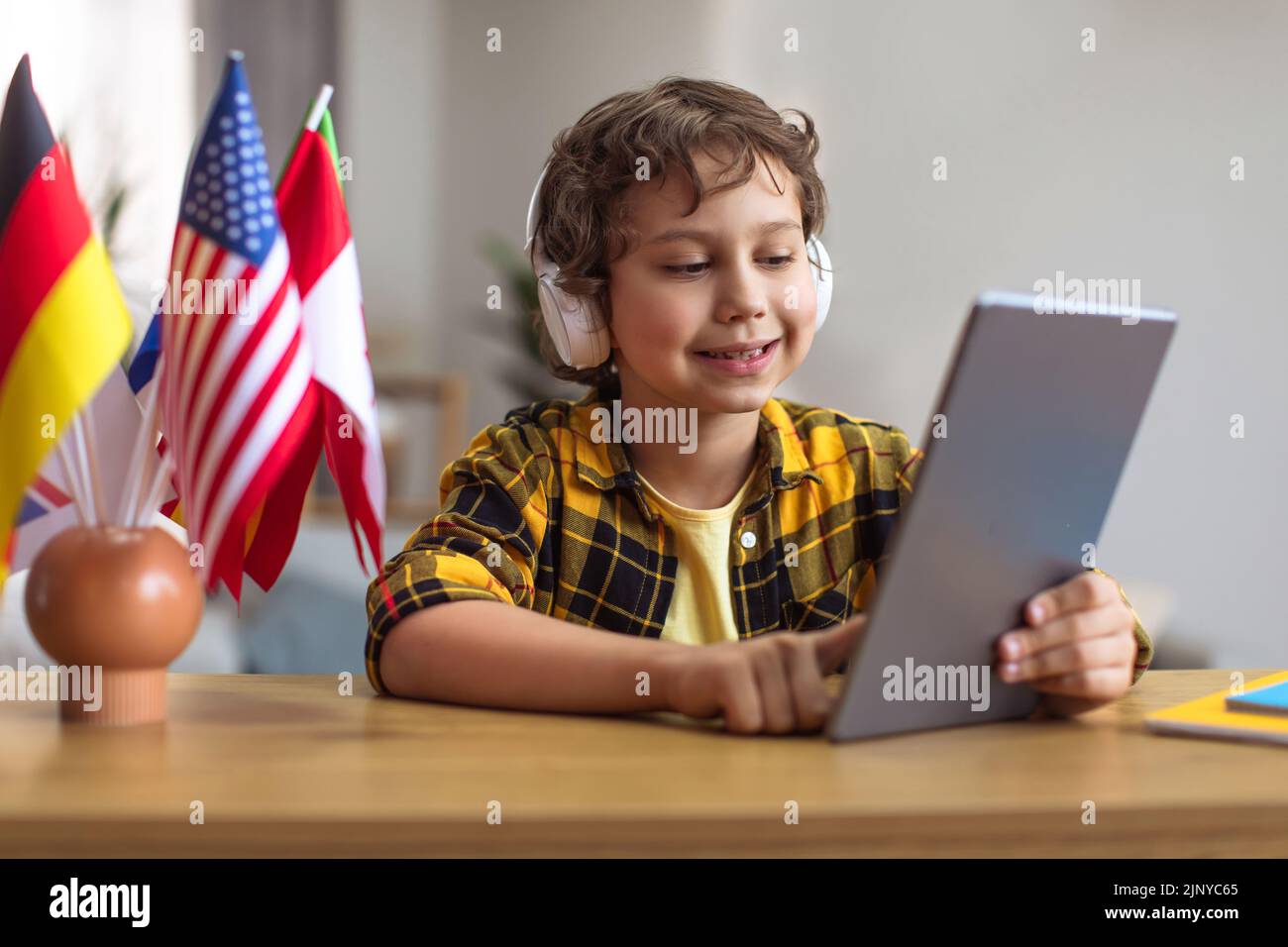 E-learning application. Cute little boy pupil using educational app on ...