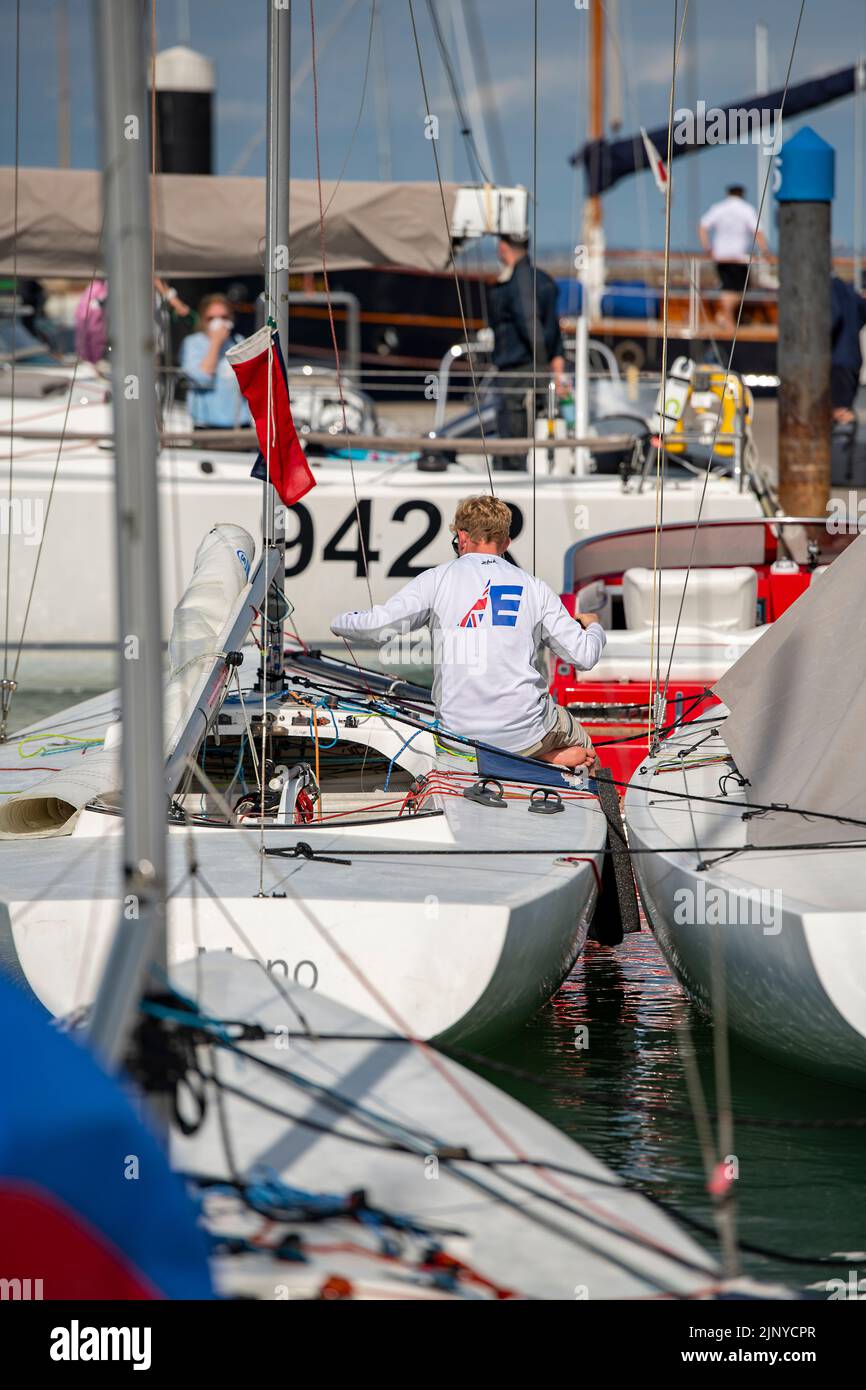 yachtsman amongst the sails and rigging of a large number of racing ...