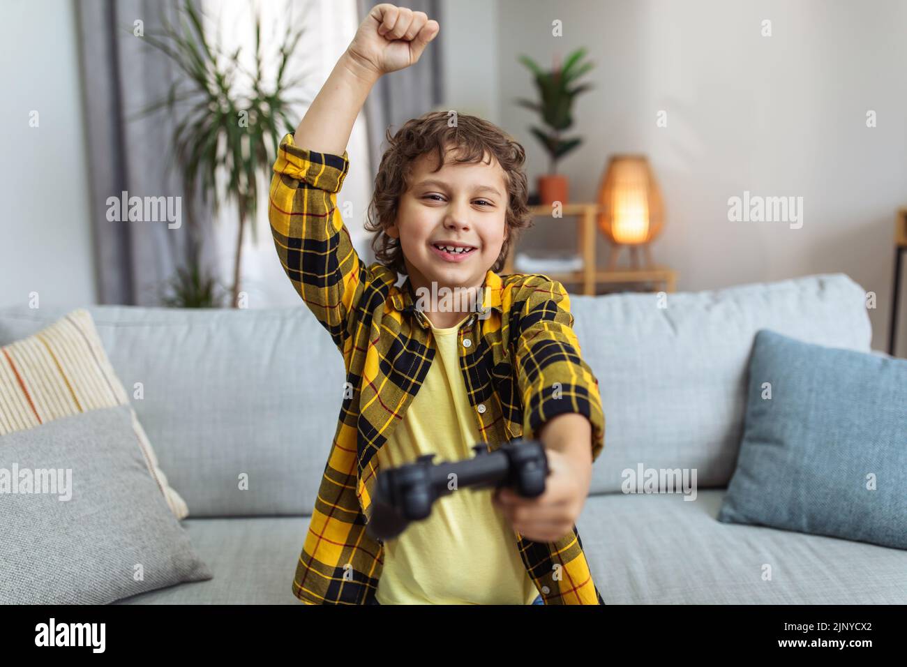 Online win. Happy little boy gamer with joystick celebrating victory in ...