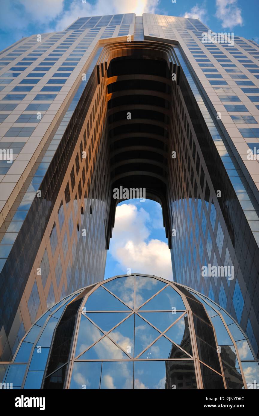 Low angle shot of a tall building with an arch. Exterior is made of ...