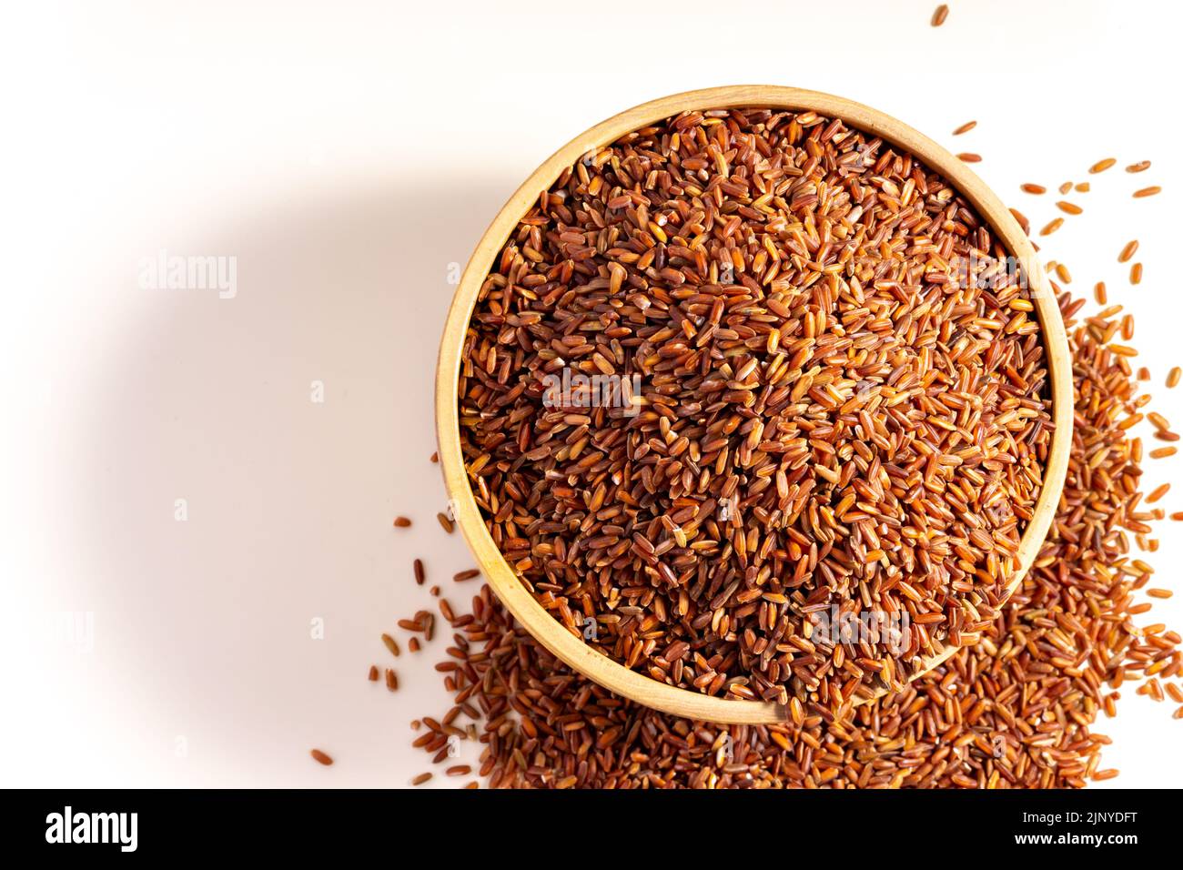 raw red rice in the wooden bowl, isolated on white background, clipping ...