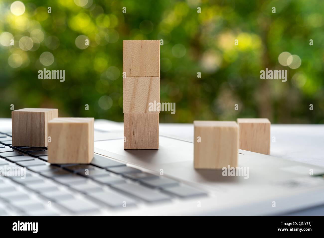 Three stack of wood block on top of laptop Stock Photo - Alamy