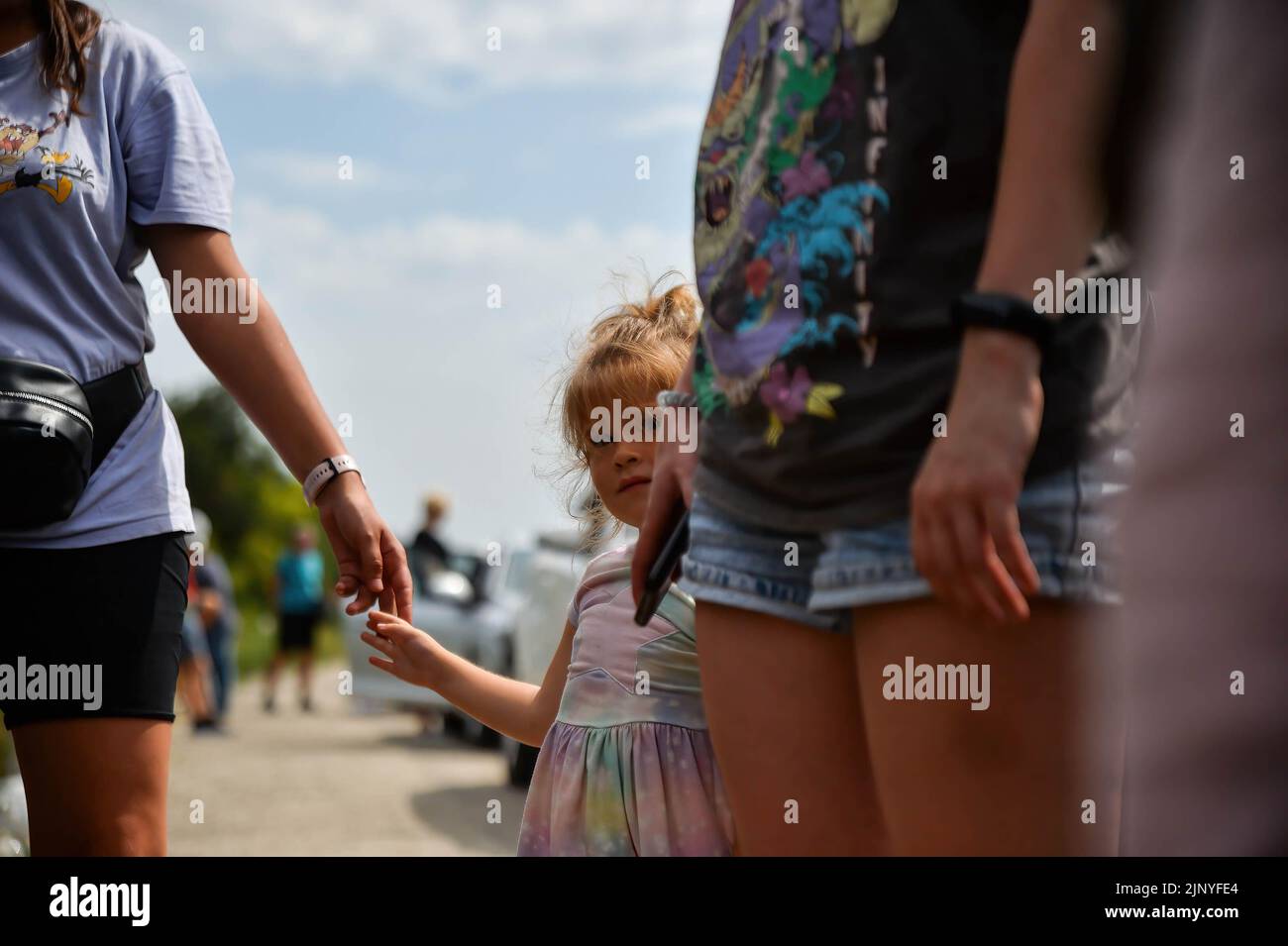 A young girl stands with her family after fleeing Russian occupied ...