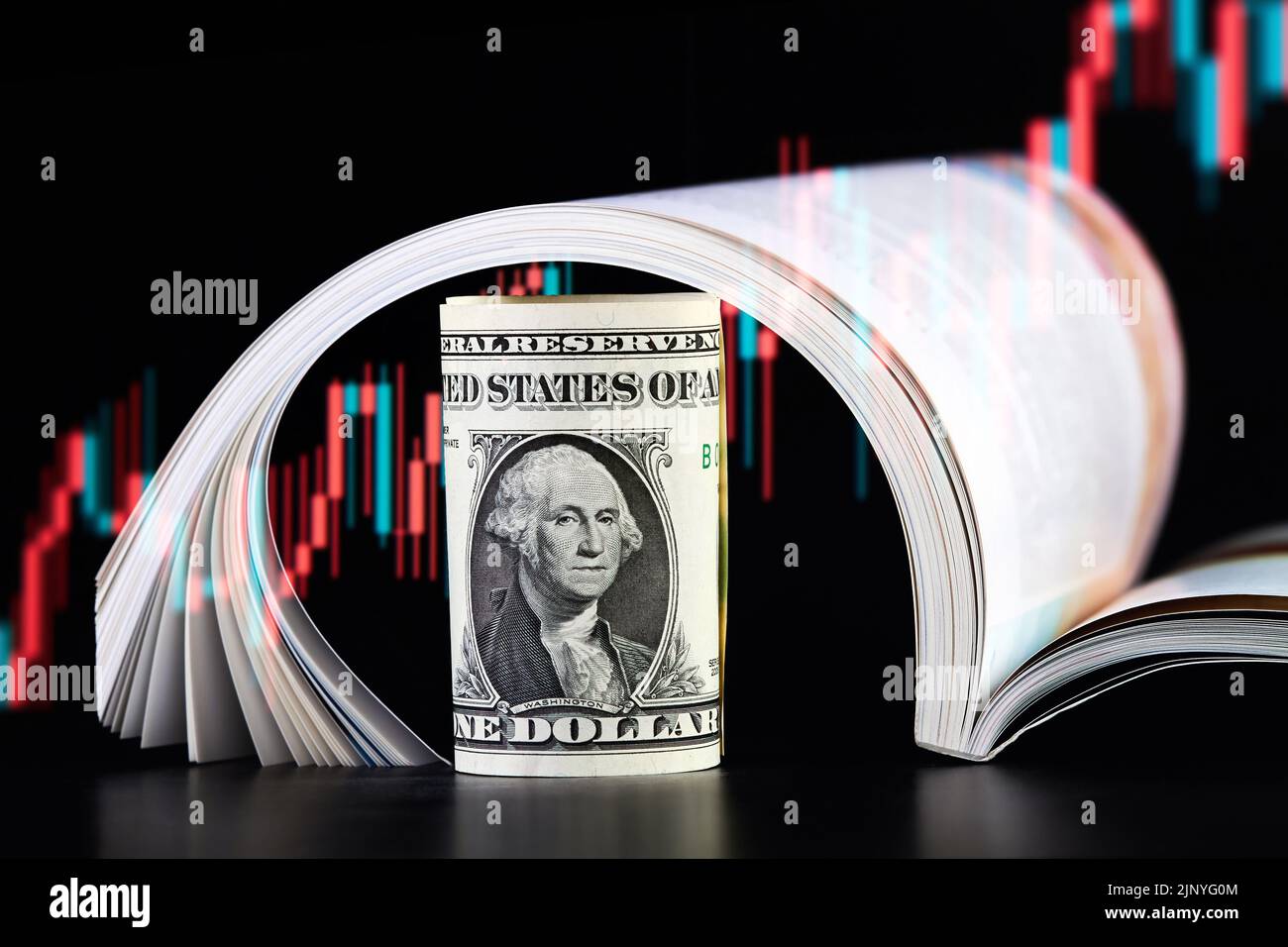 Rolled one dollar bill next to an open magazine Stock Photo - Alamy