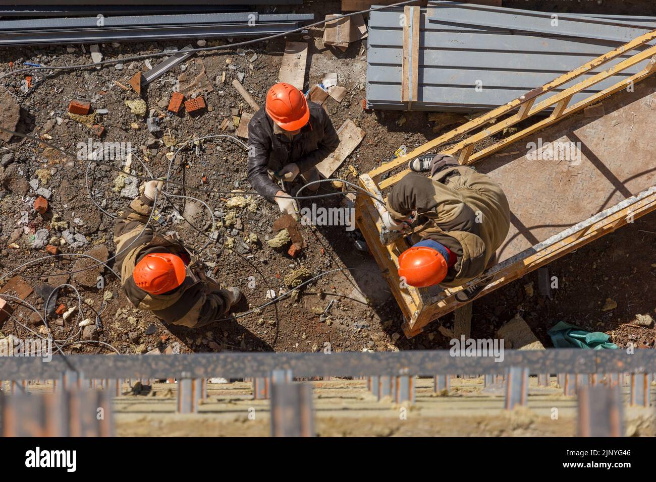 Builders at the construction site. View from above. Workers discuss ...