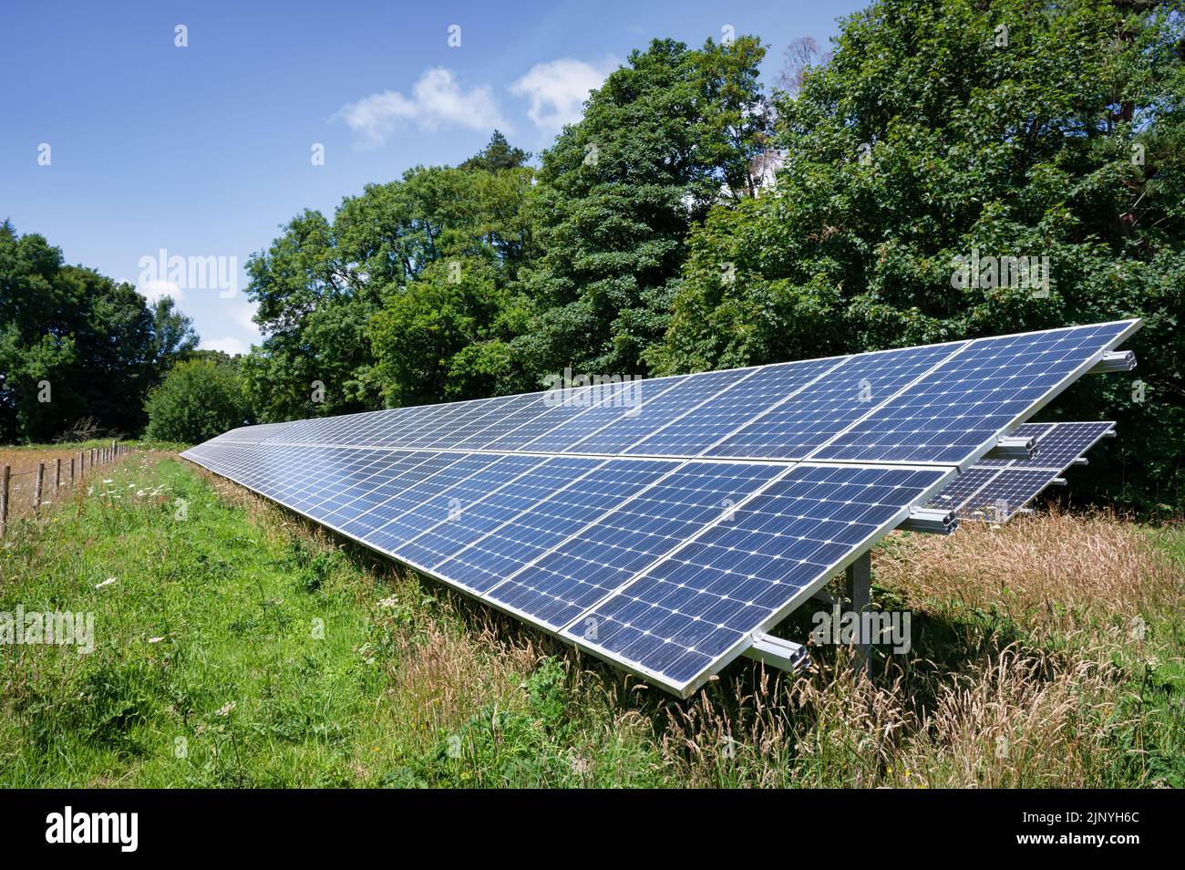 A row of solar panels installed in a rural field in the United Kingdom ...