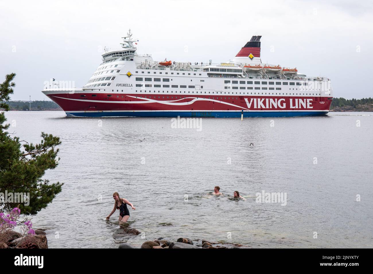 People swimming as cruise ship M/S Amorella of Viking Line shipping ...