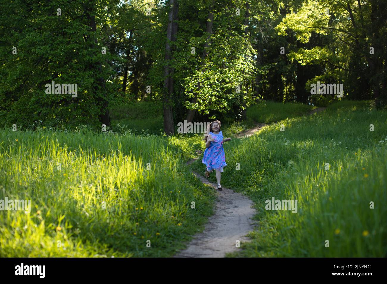Happy cute little girl running on the grass in the park. Happiness ...