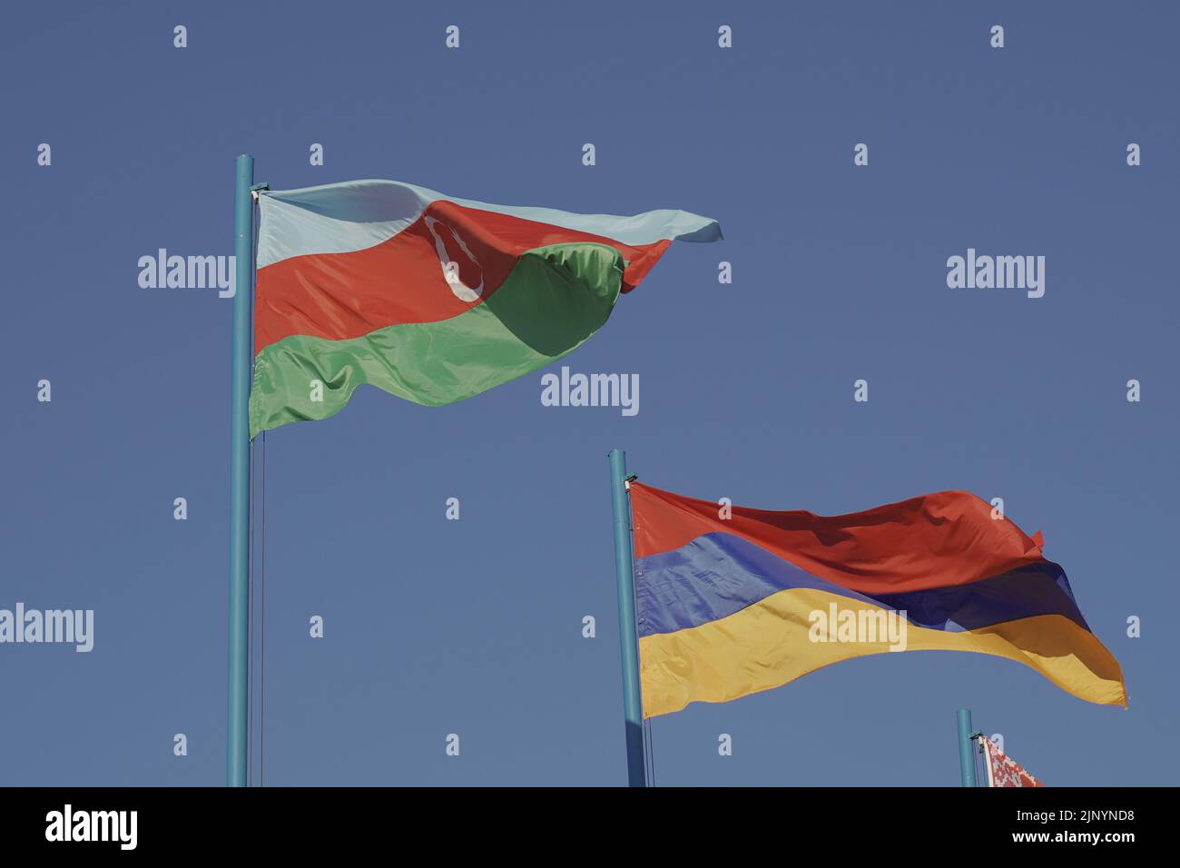 The national flags of Azerbaijan and Armenia are fluttering in the wind ...