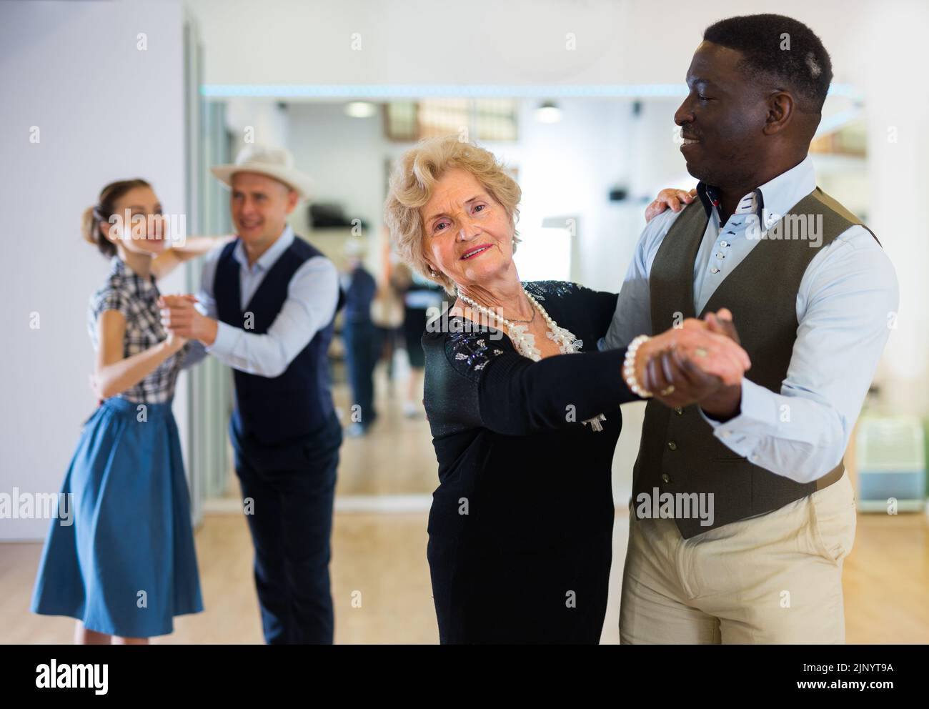 Elderly woman learning ballroom dancing in pair in dance studio Stock ...
