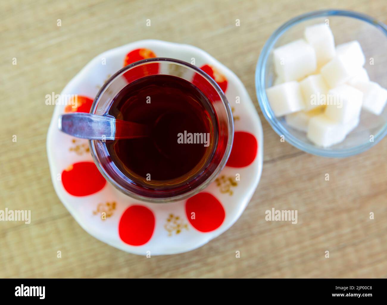 Turkish hot black tea served in traditional glass with sugar cubes ...