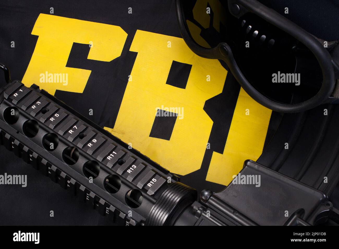 assault rifle and protective helm with goggles on fbi raid jacket black ...