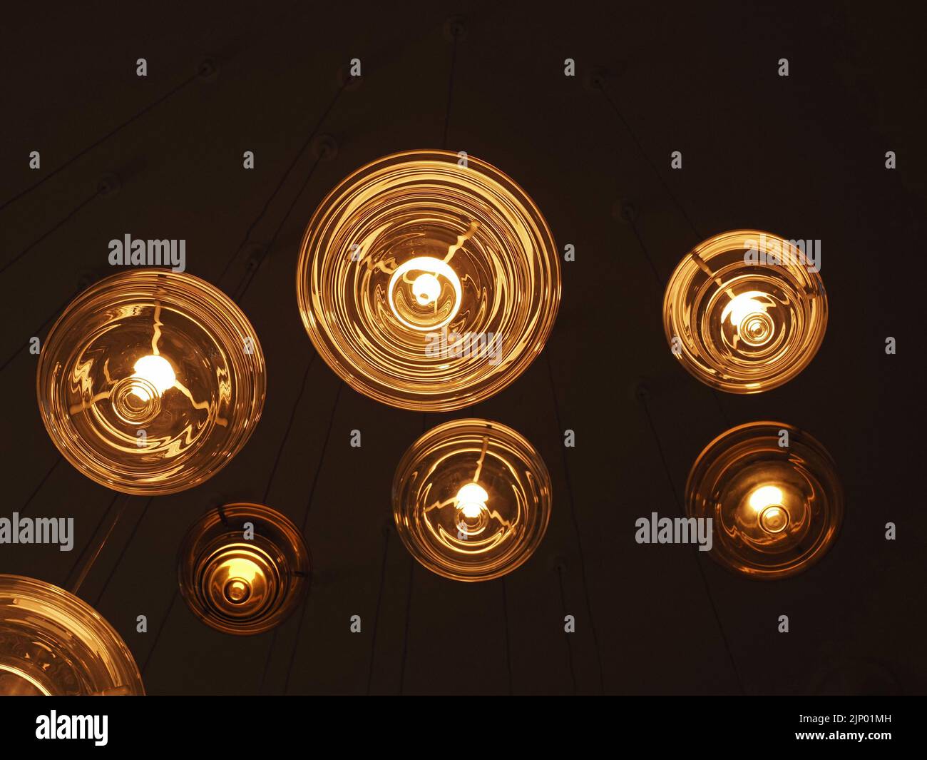 dramatic contrast of varying circular overhead electric lighting units ...