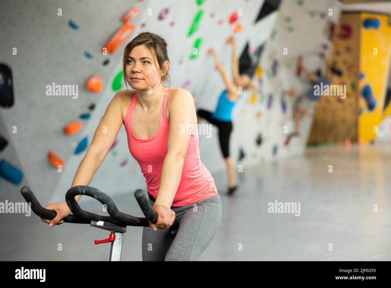 Woman riding exercise bike in climbing gym Stock Photo - Alamy