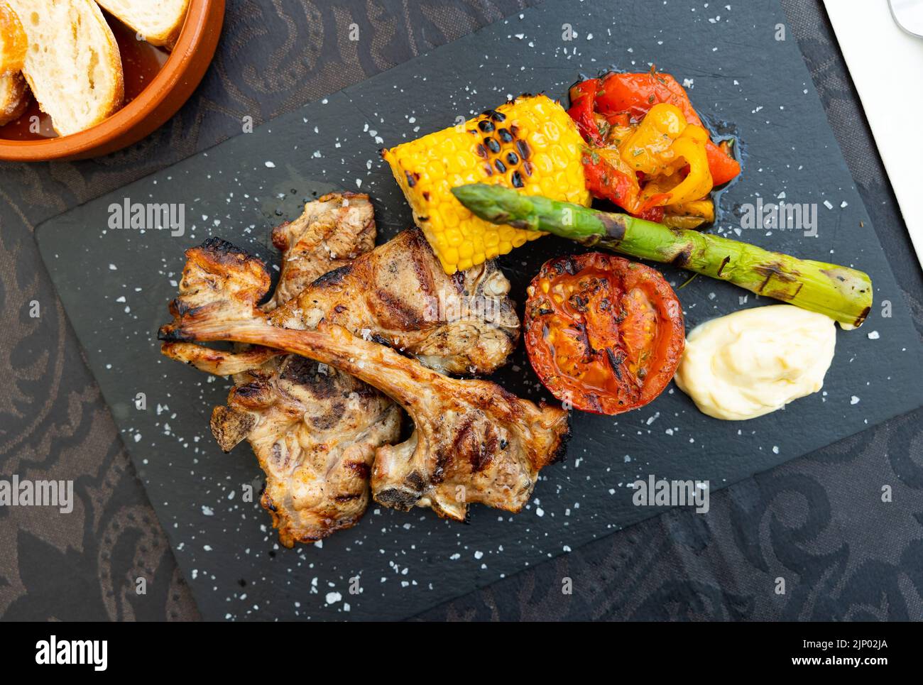 Grilled mutton chops with baked bell peppers, asparagus, tomato and ...