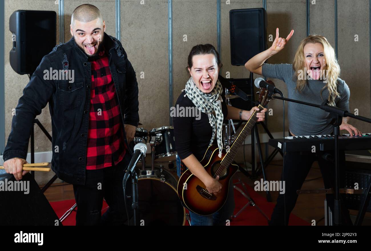 Laughing guitarist, drummer and keyboardist Stock Photo - Alamy