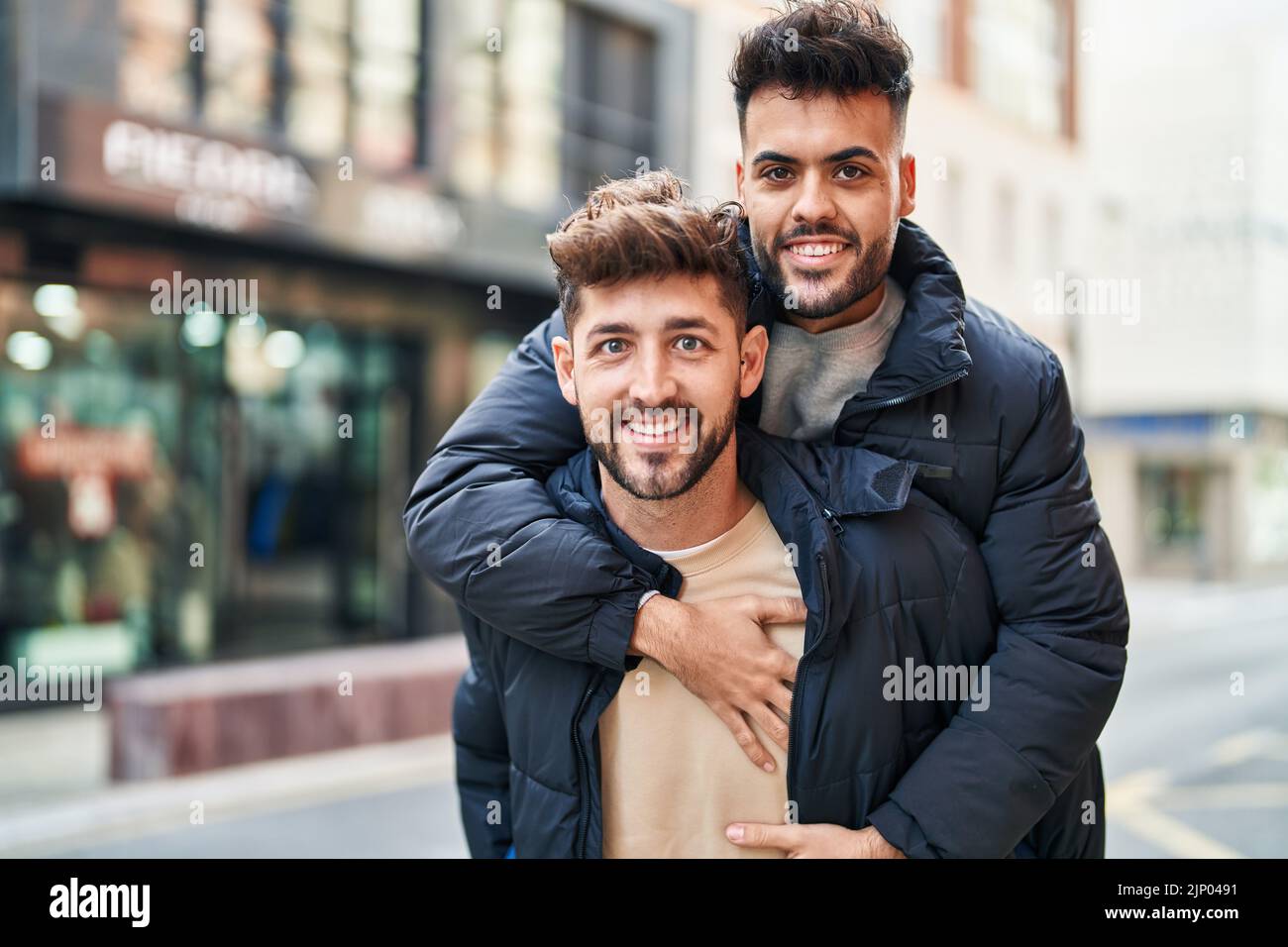 Young couple smiling confident holding boyfriend on back at street ...