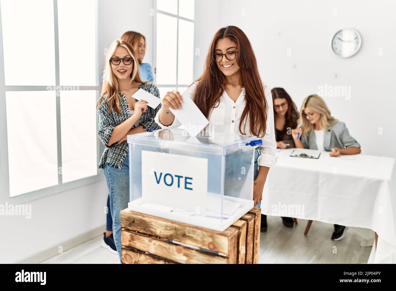 Group of young voter woman smiling happy putting vote in voting box at ...