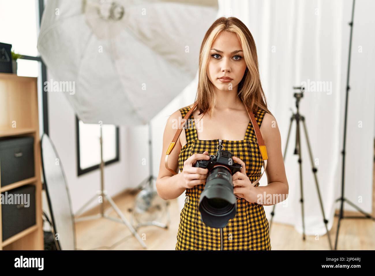 Young caucasian photographer girl holding professional camera at ...