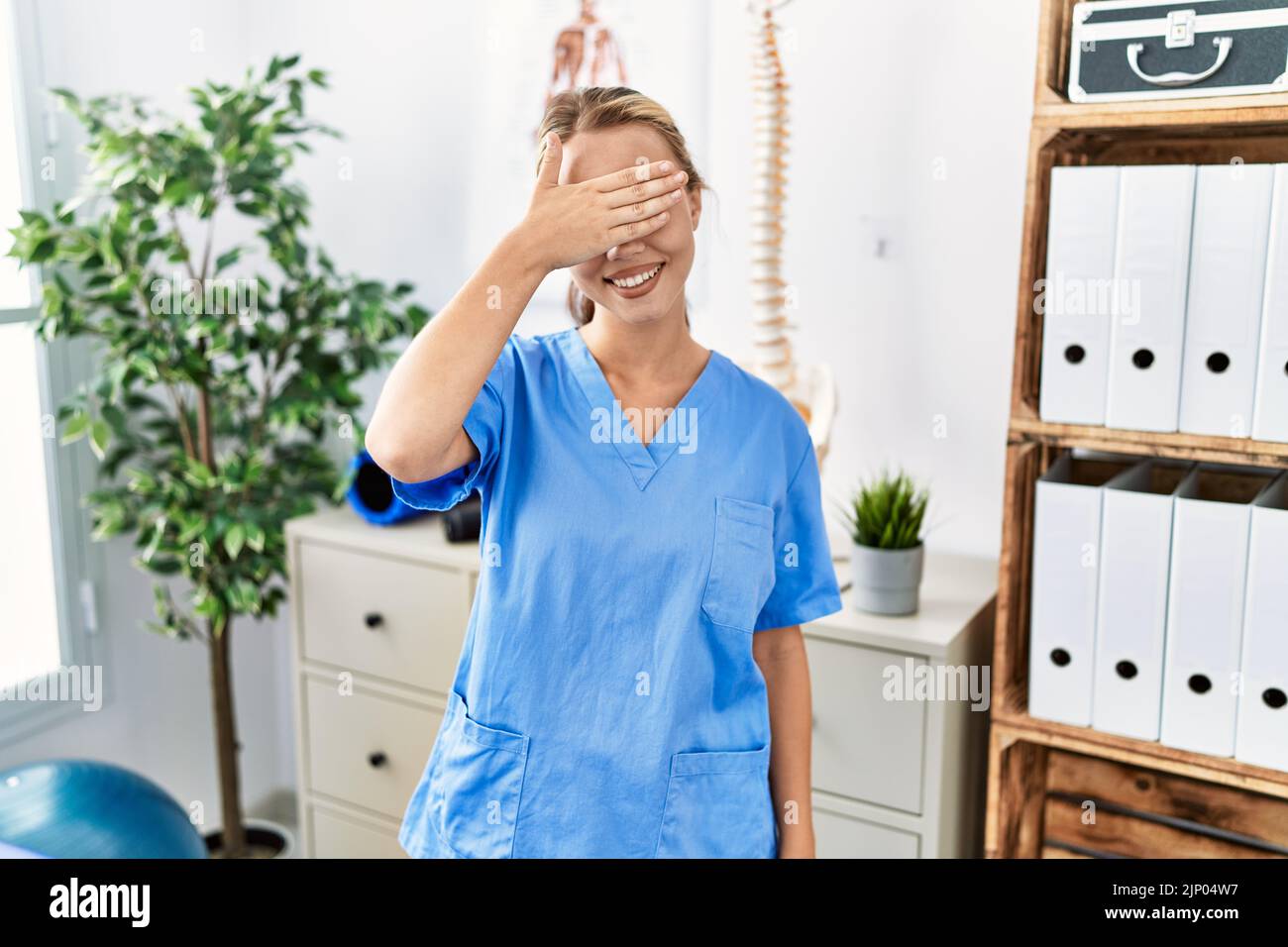 Young caucasian woman working at pain recovery clinic smiling and ...