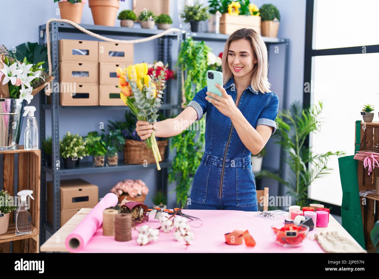 Young woman florist make photo to bouquet of flowers at florist Stock ...