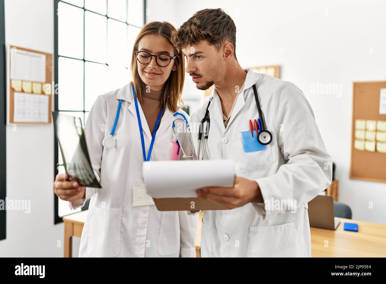 Two hispanic doctor working in a medical meeting looking bone scan at ...