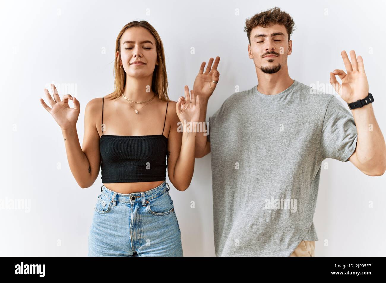 Young beautiful couple standing together over isolated background ...